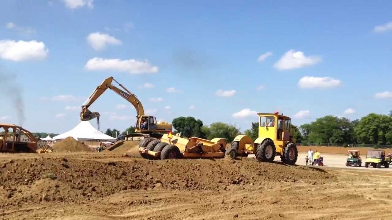 Four wheel drive tractor pulling scraper pan, IH Dozer, Deere 230LC ...