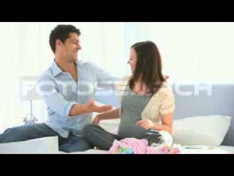Pregnant Couple Sitting On Bed