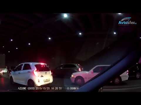 Qucağında uşaq şəhərin ortasında maşın sürür