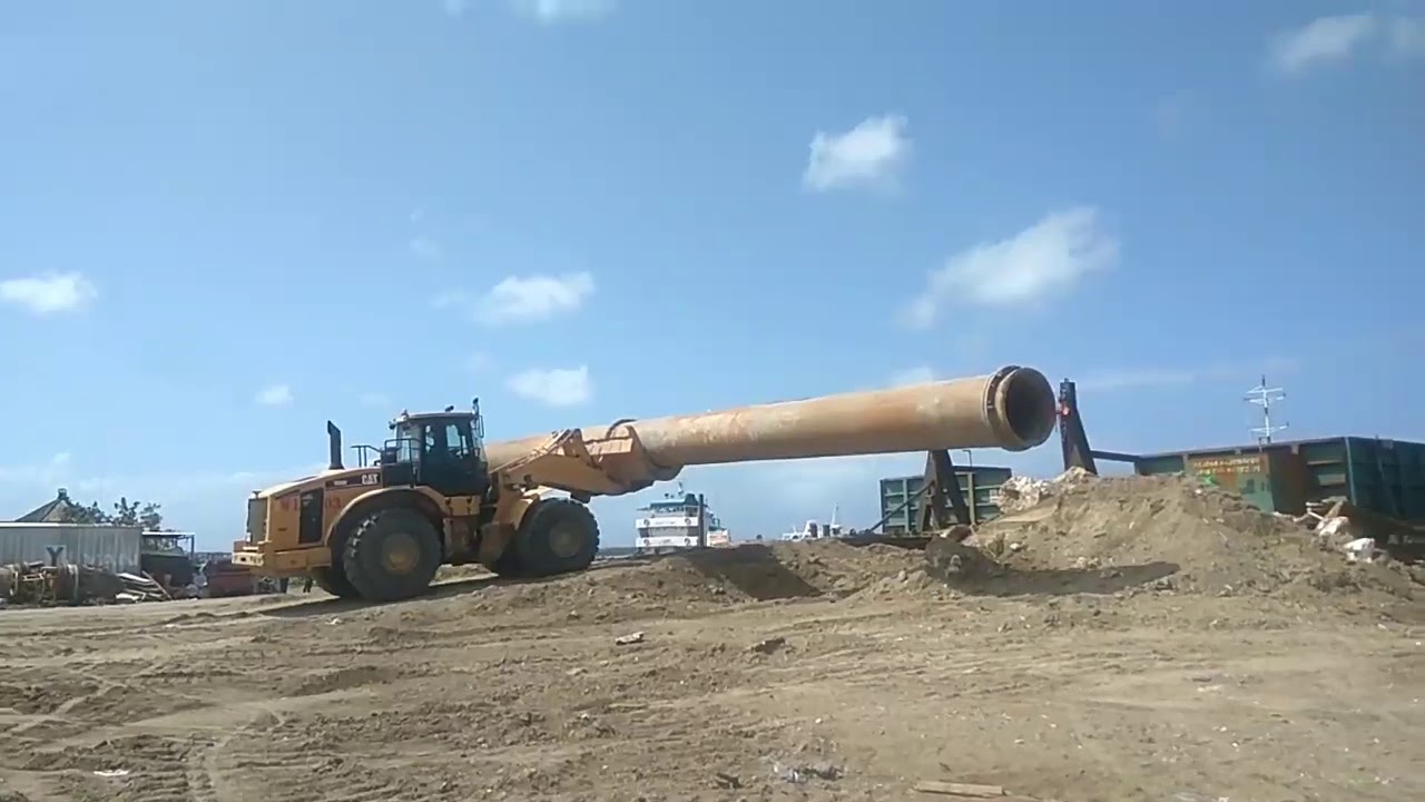CATERPILLAR wheel loader 980H load pipeline to barge - YouTube