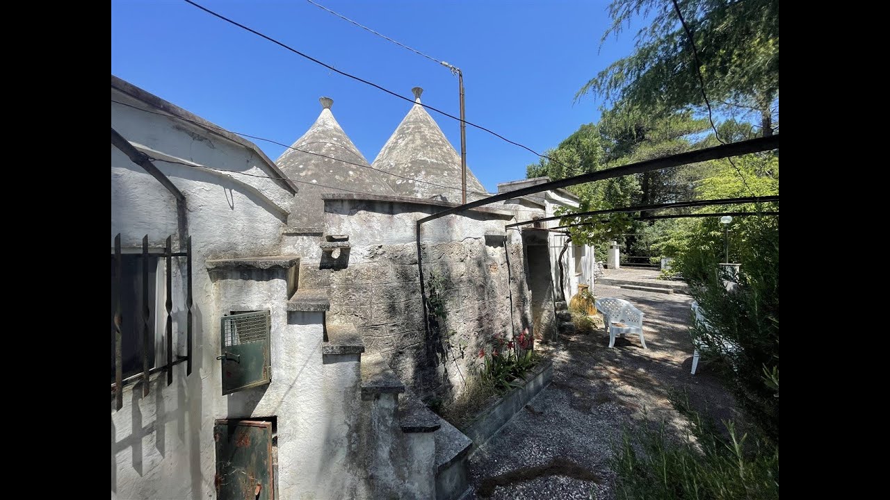 Pretty structure with trulli, lamie, and pine forest in front. - YouTube