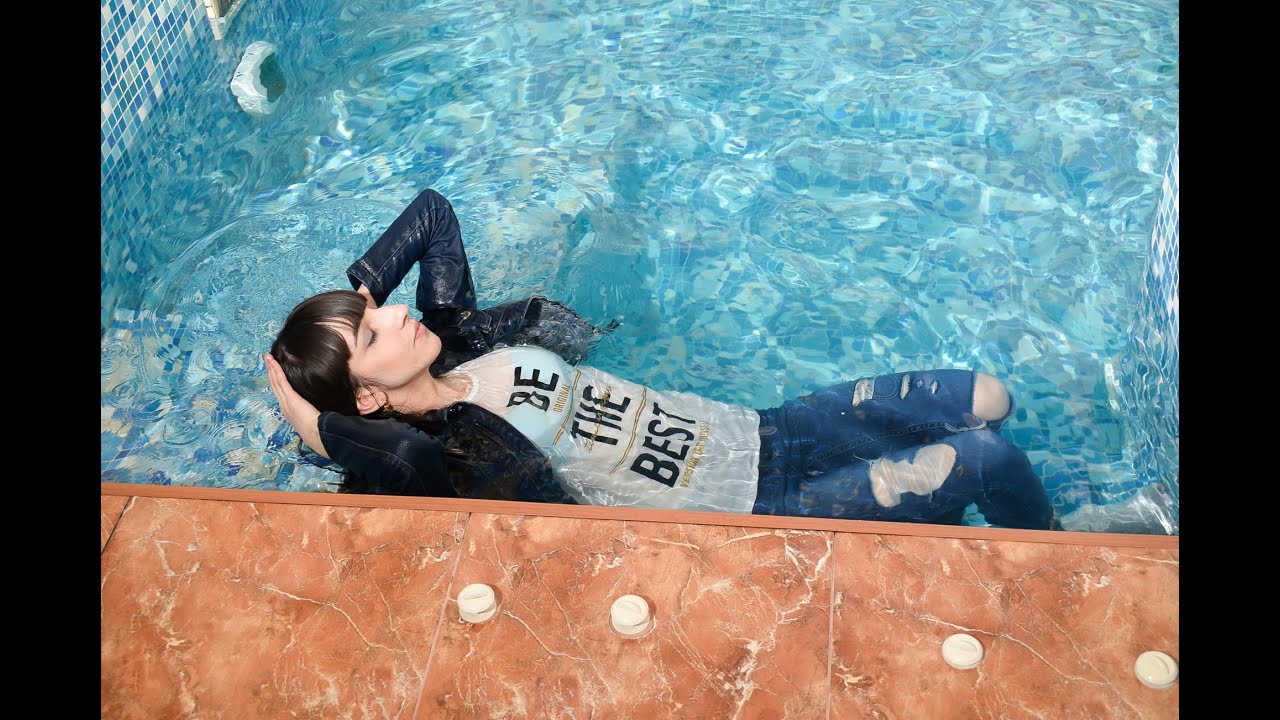 beautiful girl in a wet denim jacket and wet jeans has a great rest in ...