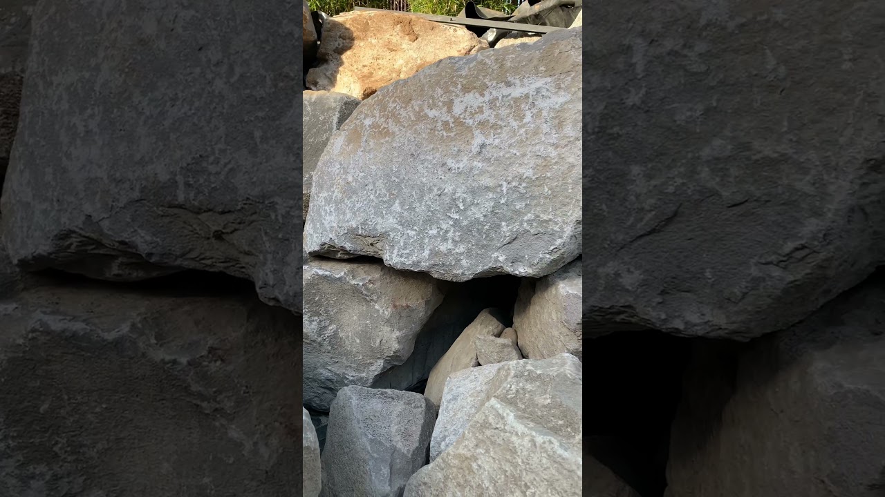 Chinking in rock walls in pond - YouTube