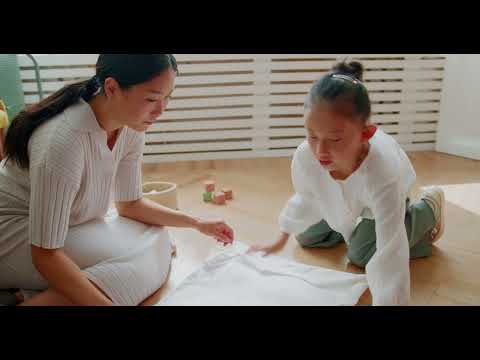 GIRL FOLDING CLOTHES WITH MOTHER