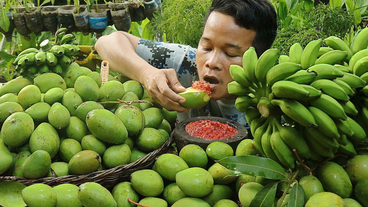 Man eating mango fruits, many kind of fruits eat with spicy salt Mouth ...