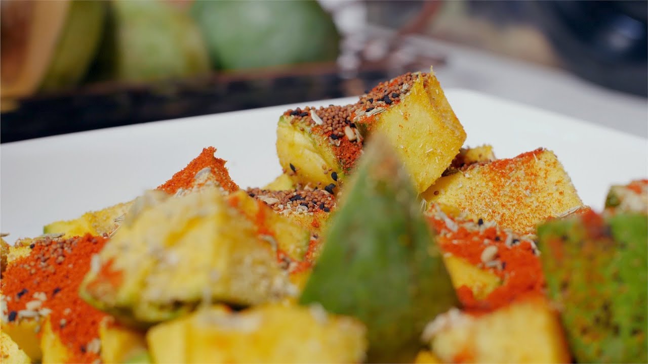 A woman adding yellow mustard seeds / sarso / rai into the raw ...