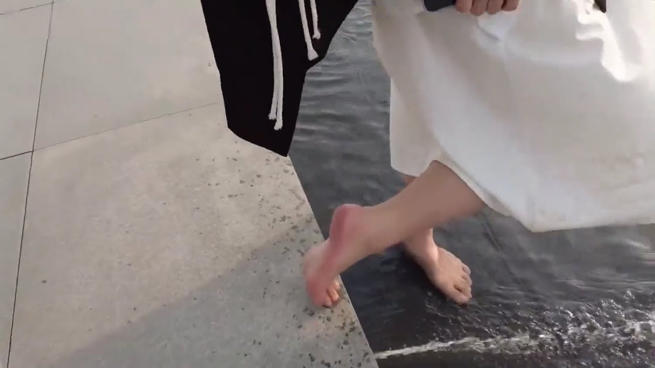 Chinese girls walking barefoot outdoors and washing their feet in the ...
