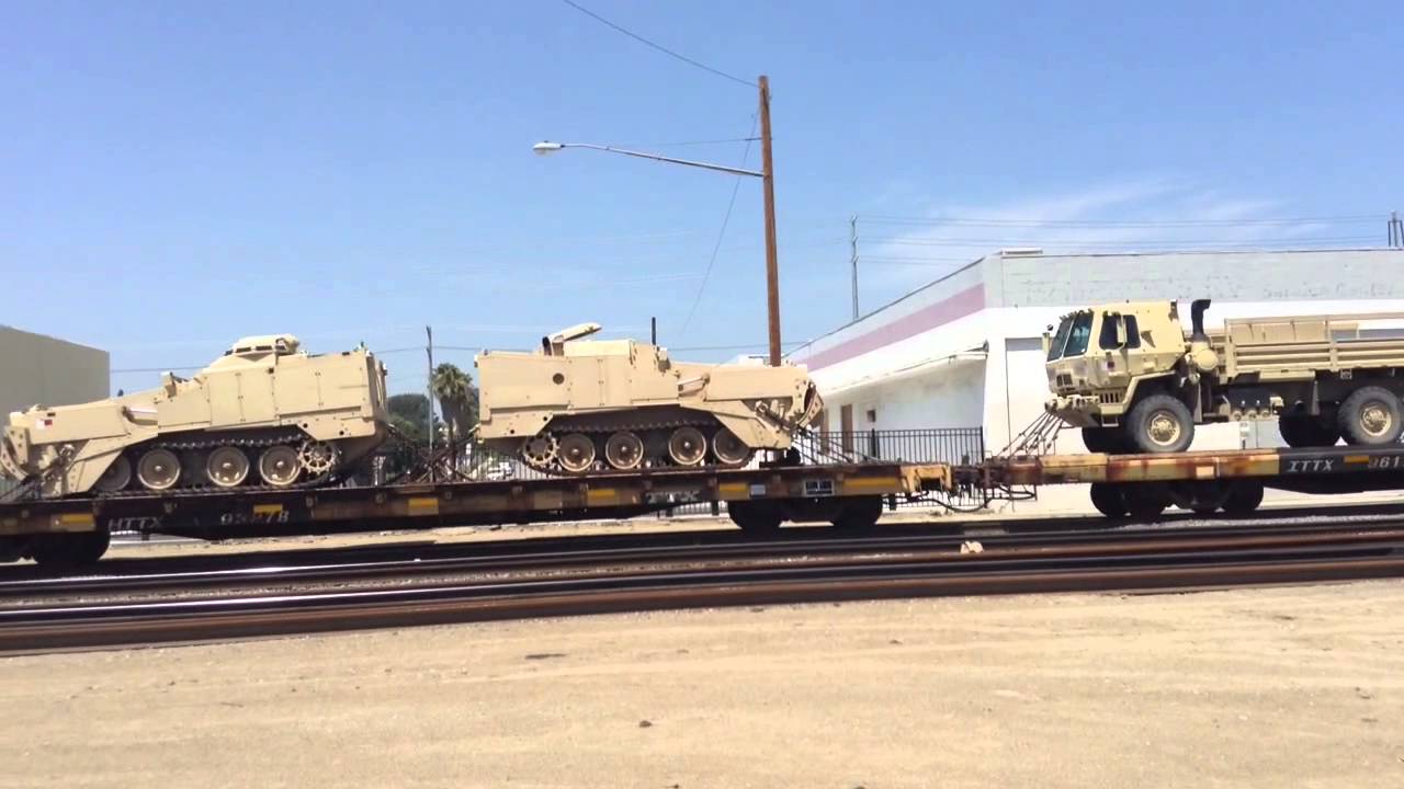 Train full of military vehicles going through town - YouTube