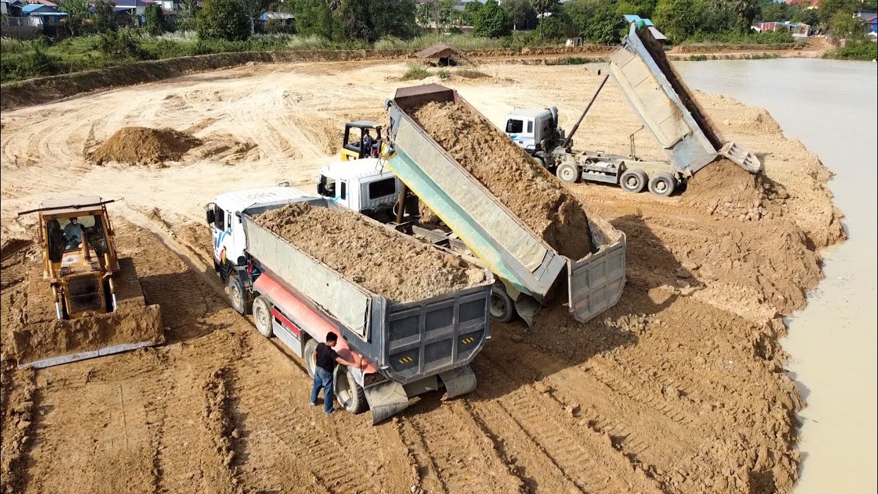 Big pits Land Filling Up Heavy dump truck 25T unloading soil and 2 ...