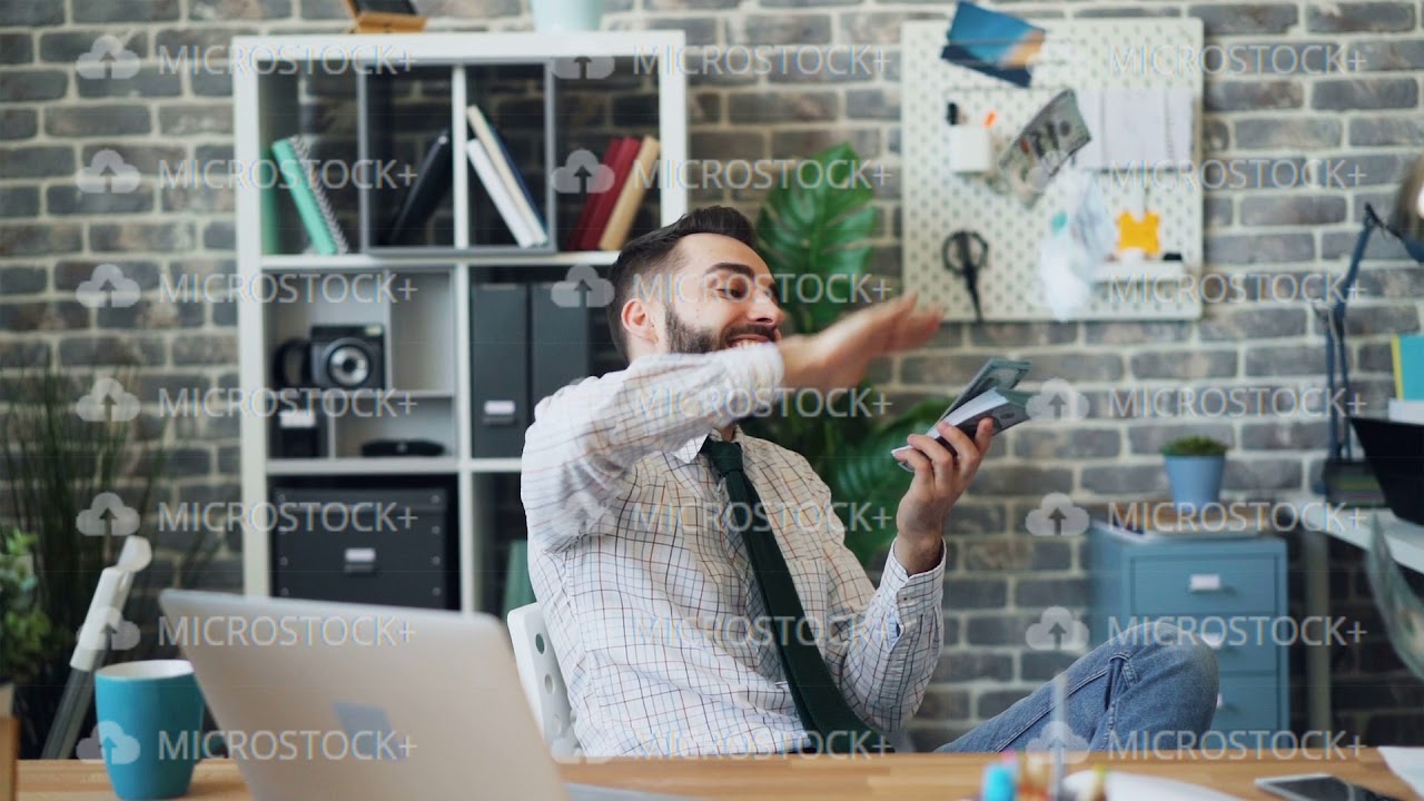 Slow motion of happy millionaire throwing money laughing in office ...
