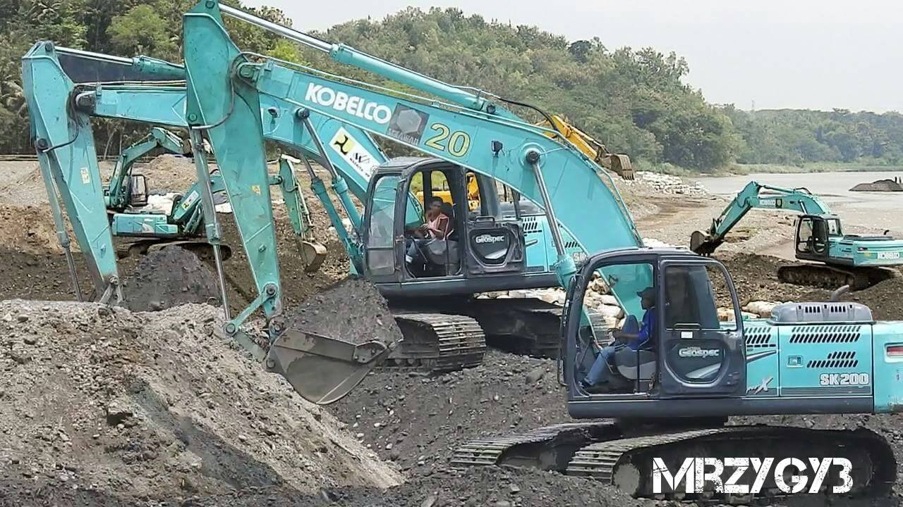 Kobelco SK200 Excavators Stockpiling Sand On River Dam Construction ...