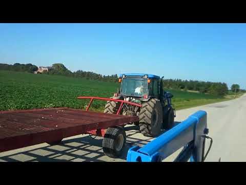 Tractor passing another tractor both towing bale wagons lol