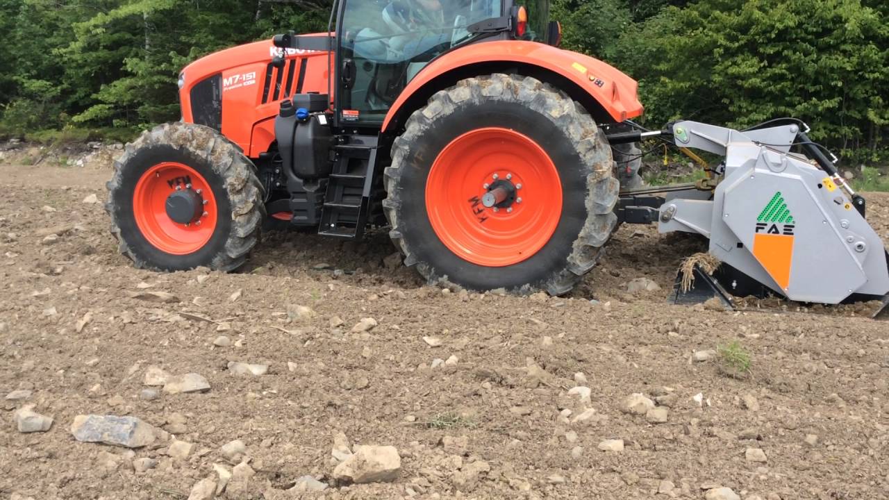Kubota M7 with FAE stone crusher - YouTube