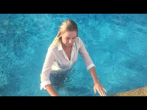 Lera ripped jeans and in a white shirt in a warm pool