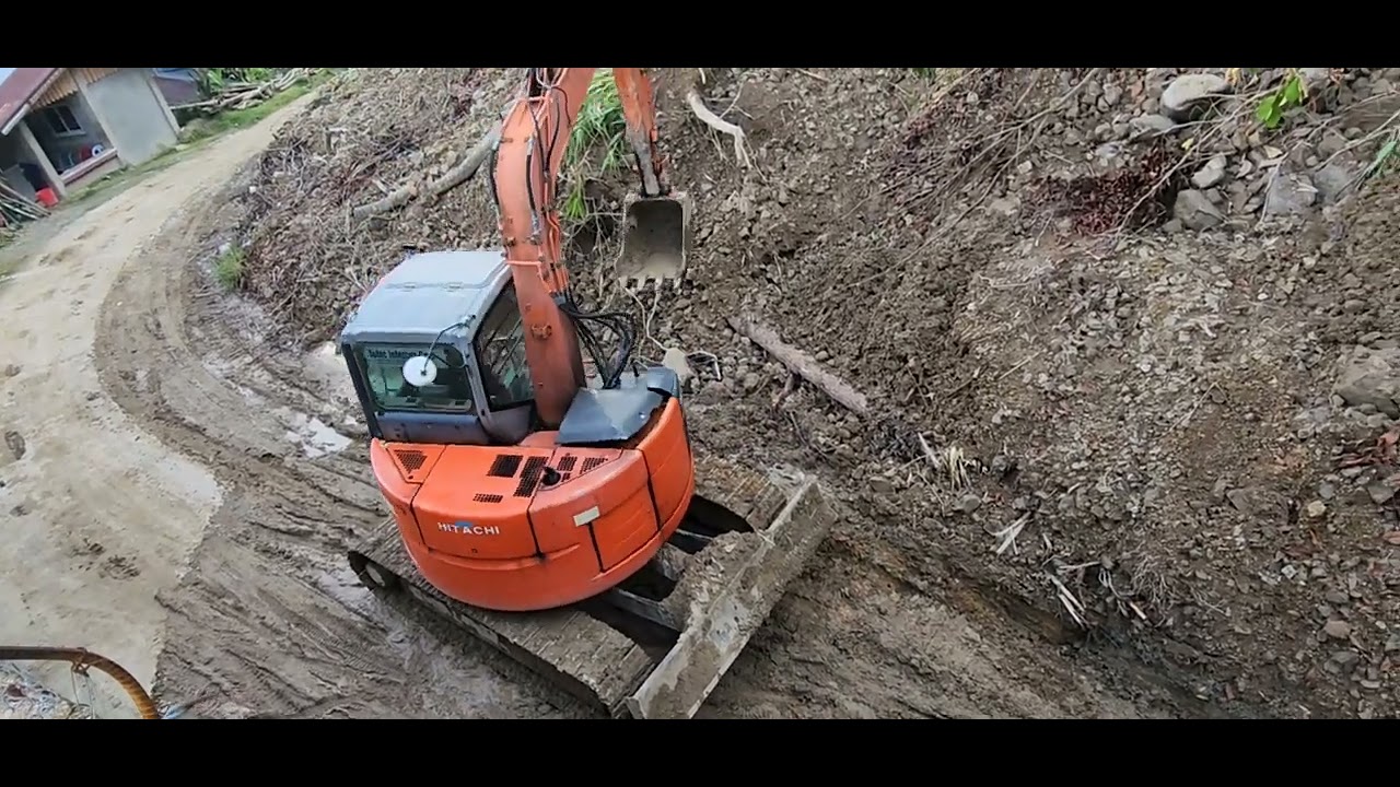 Backhoe Partialy fixing the road for the convenience of the riding ...