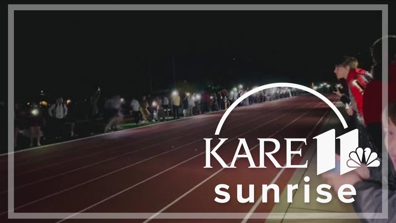 Runners illuminate the night after lights go out during track meet ...