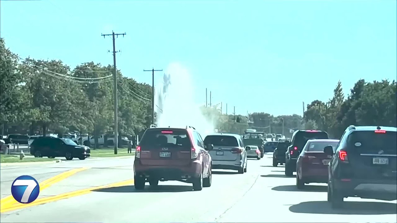 Broken fire hydrant sends water gushing into the air along busy road ...