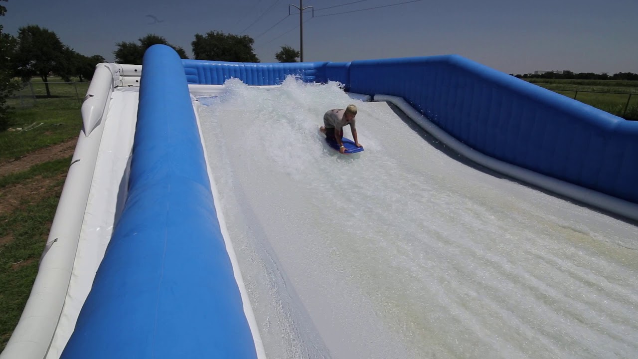 Kids entering ride on the FlowRider inflatable mobile portable machine ...