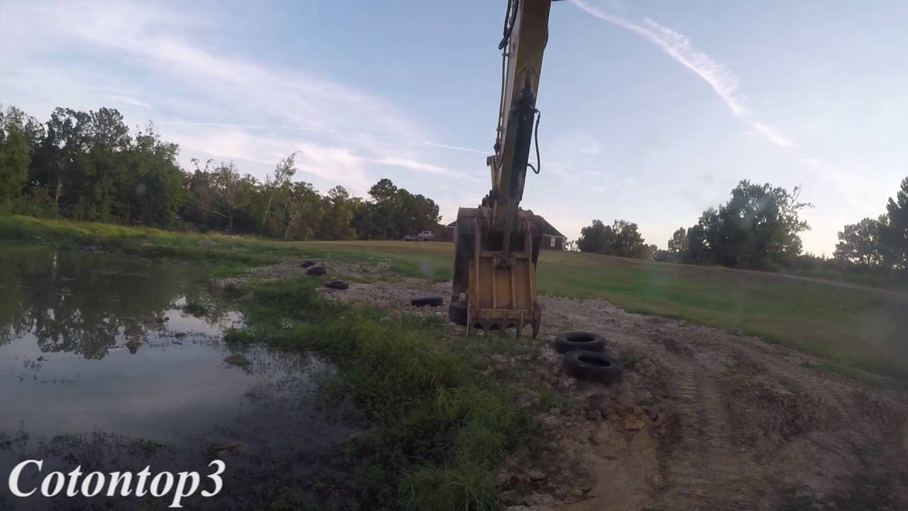 John Deere excavator sinking tires in my pond - YouTube