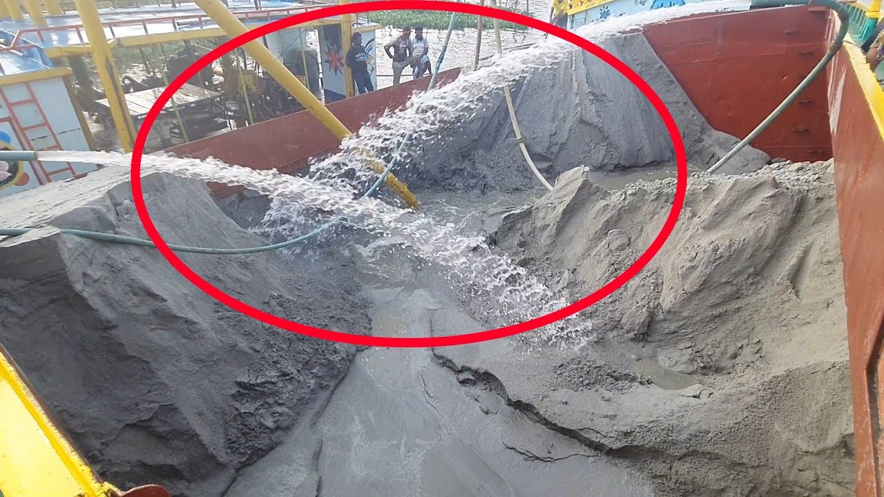Sand is being unloaded from large ships with powerful dredger machines ...