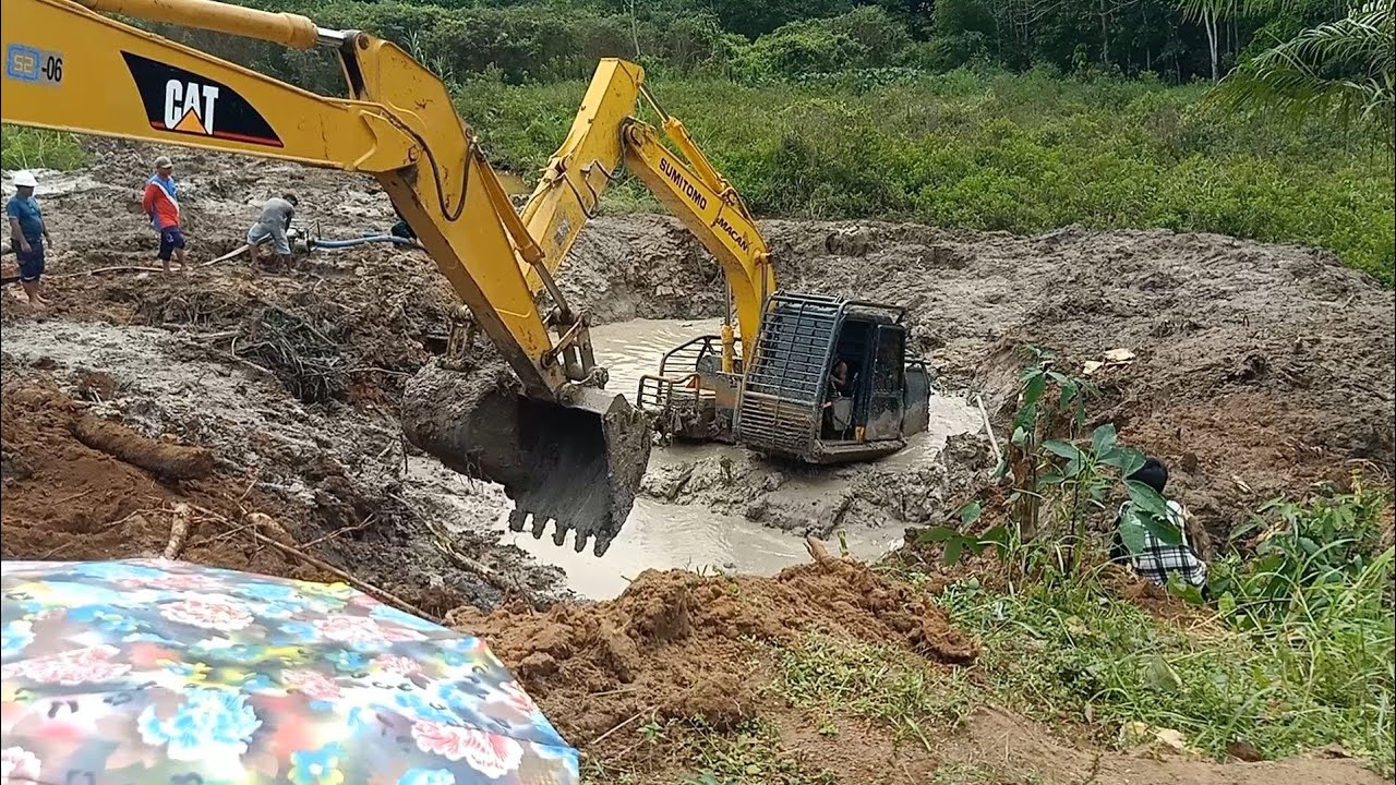 a caterpillar excavator evacuated a sumitomo excavator stuck in the mud ...