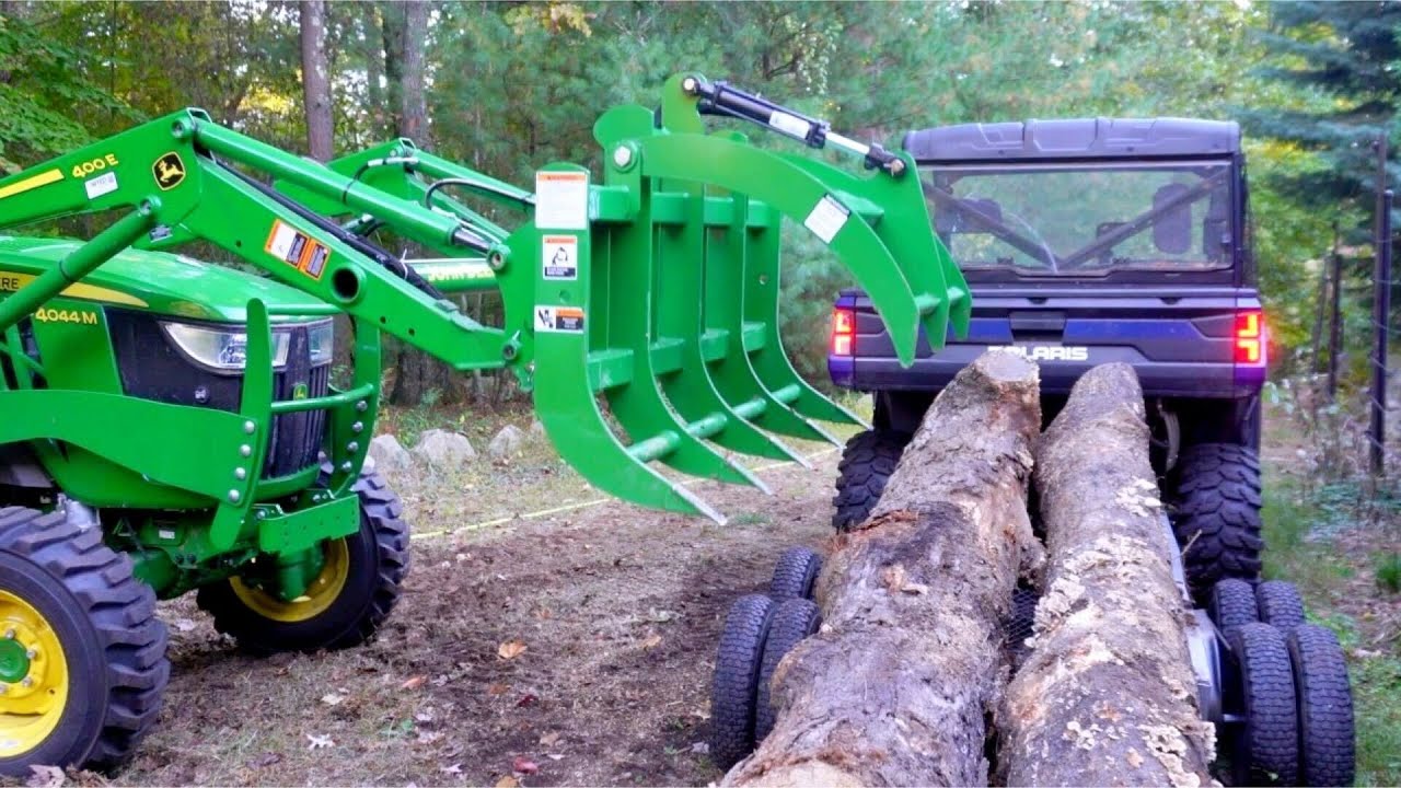 Compact tractor with grapple moving logs - YouTube