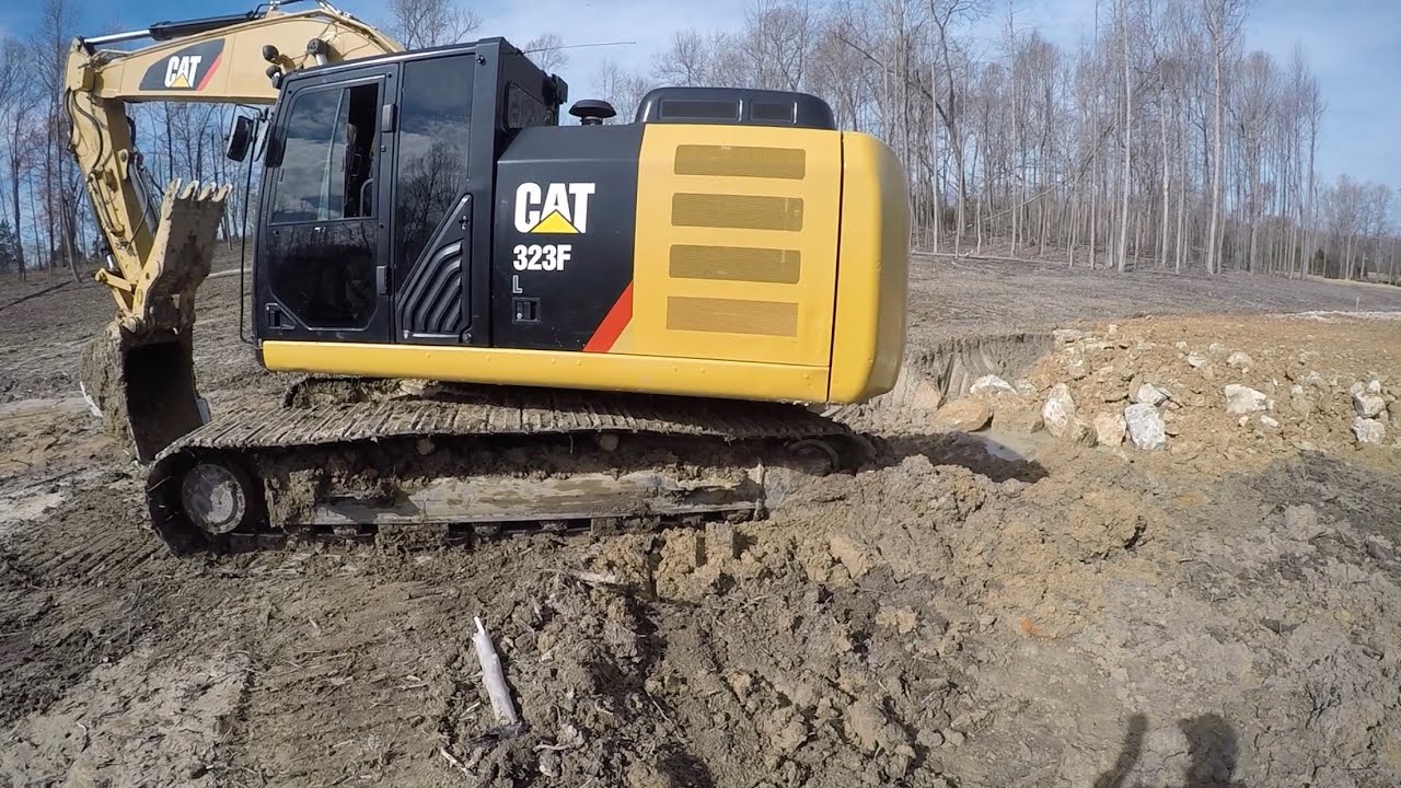 Building a road through a swamp. Undercutting and filling with rock ...