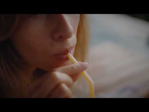 Blonde woman drinks mango shake closeup #summer #bikini #beach