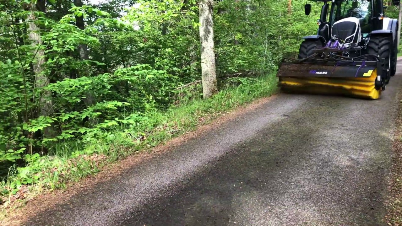 Valtra tractor sweeps wood chips and moss with a Holms Sweeper Light ...