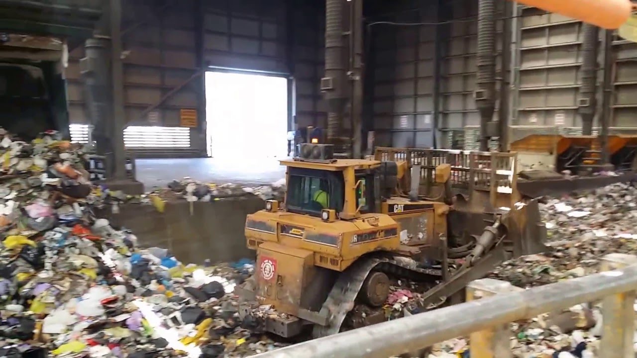 Garbage truck unloads to Bull Dozer at the Tip - YouTube
