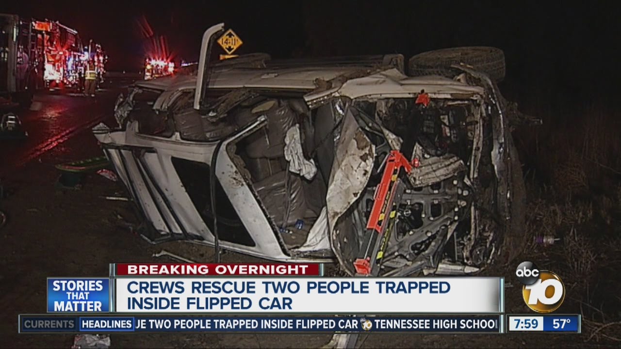 Crews rescue two people trapped inside flipped car - YouTube
