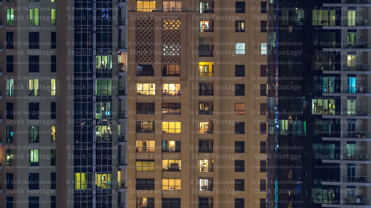 Glowing windows in multistory modern glass and metal residential ...