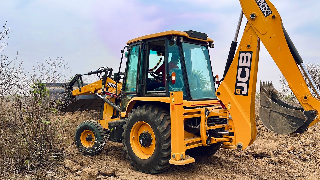 Soil cutting by jcb backhoe loader in farming field in village area ...
