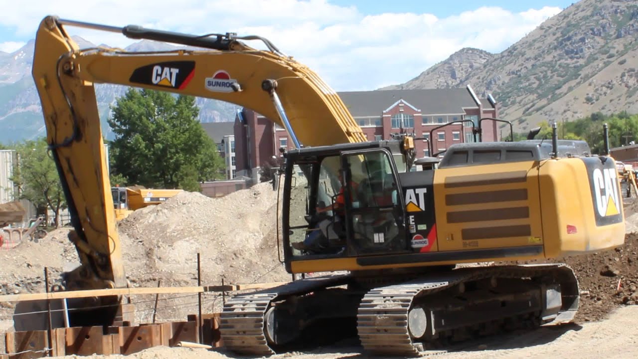 CAT 336E Excavator digging dirt with a huge bucket on a large work site ...