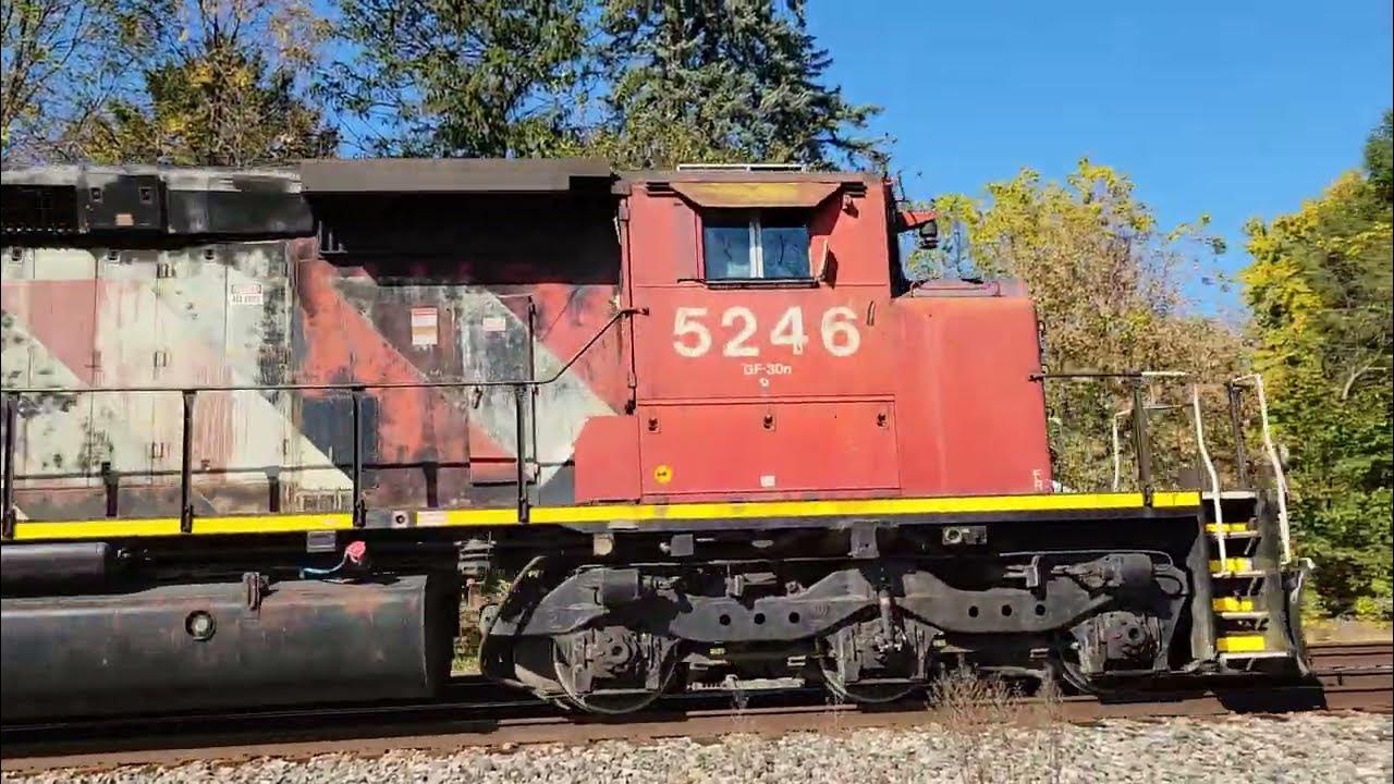 CN 5246, 5419 Eastbound local freight train with center beam flat cars, covered hoppers - YouTube