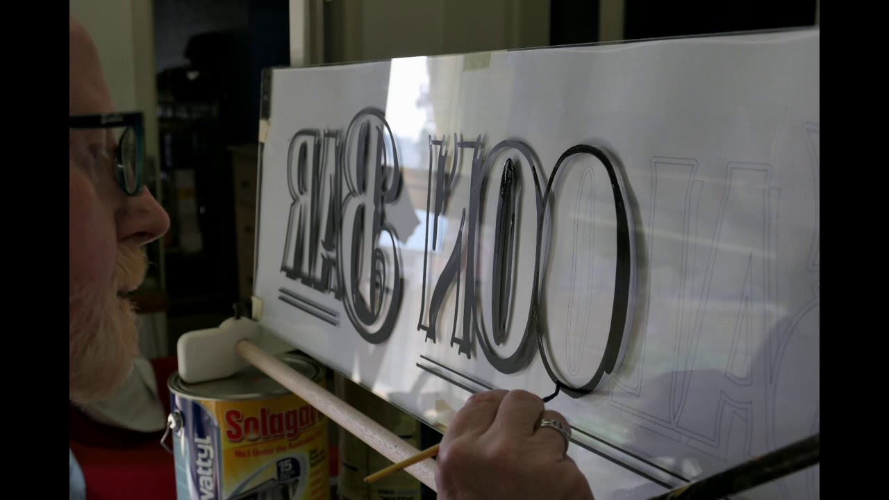 Signwriting the design in reverse on the back of the glass - YouTube