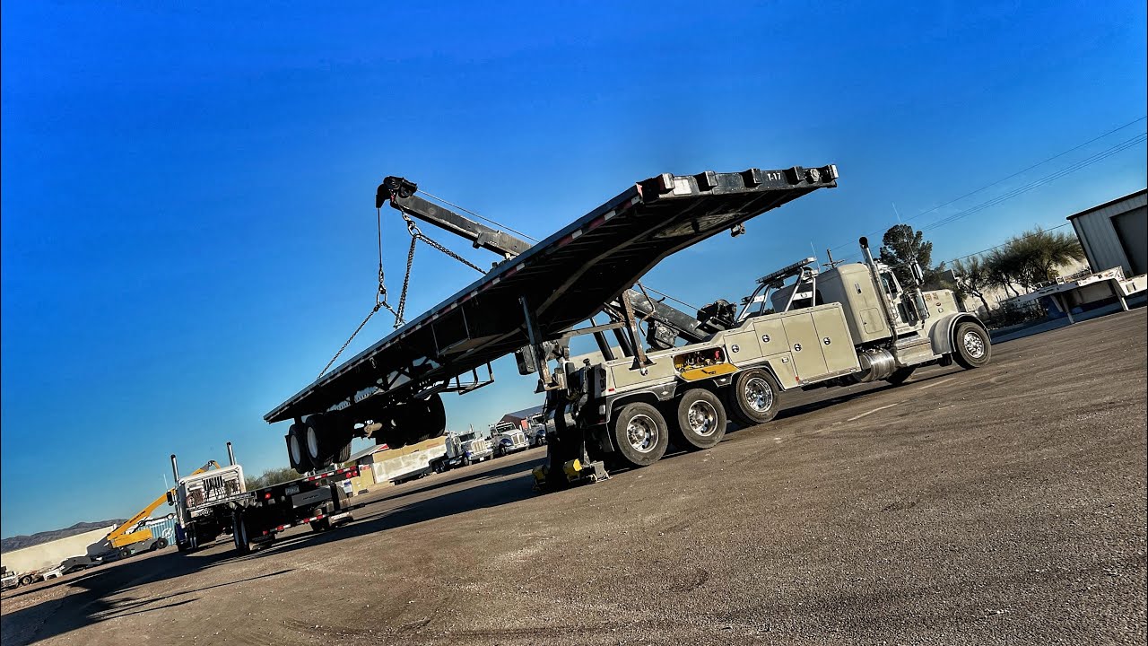 Stacking flatbed trailers with a wrecker. - YouTube