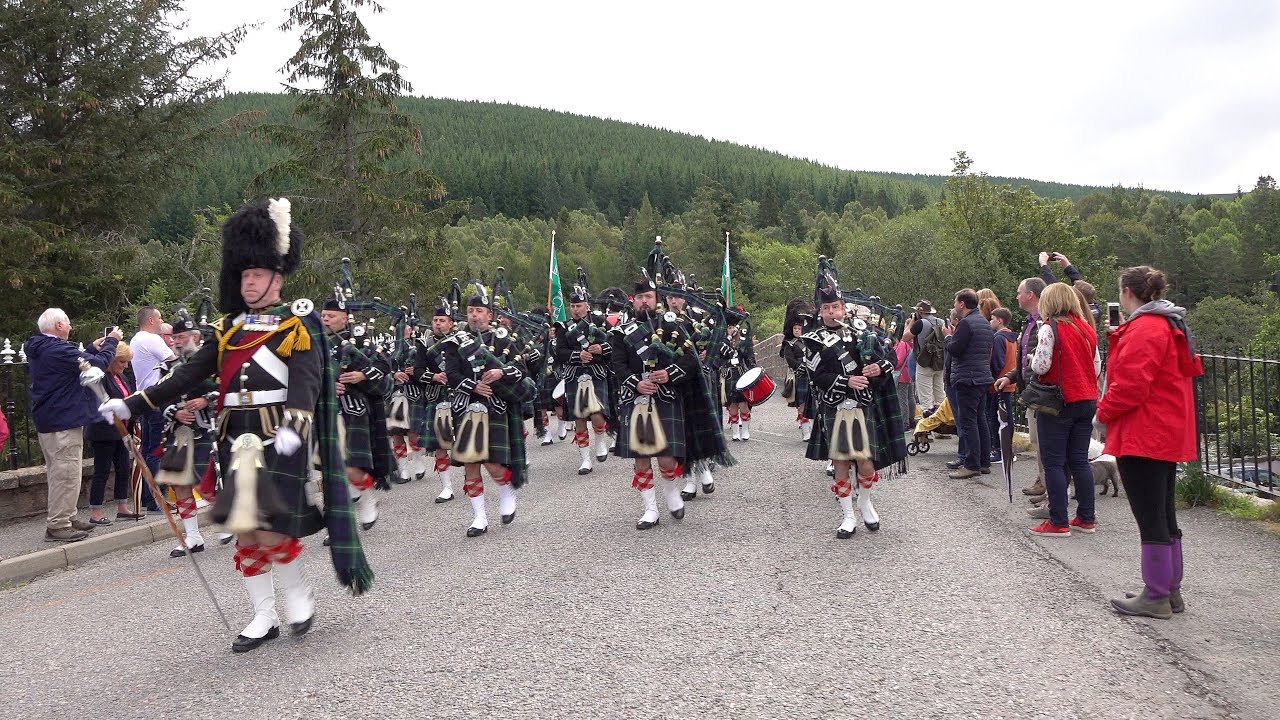 Lonach Highlanders march over the river Dee into Ballater followed by ...