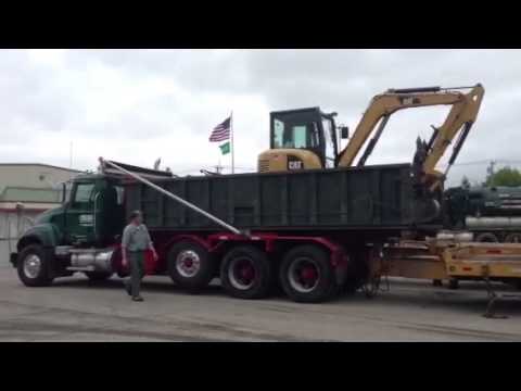 Loading a cat mini excavator into a Mack roll off - YouTube