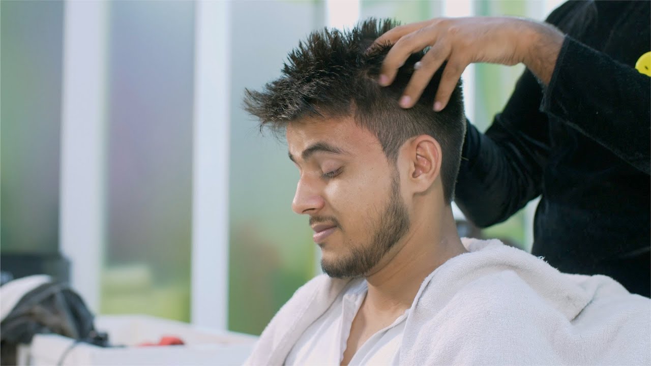 A young Indian boy / man enjoying head massage at a spa / salon ...