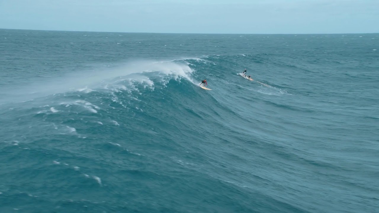 4k aerial shot of surfer riding wave s - YouTube