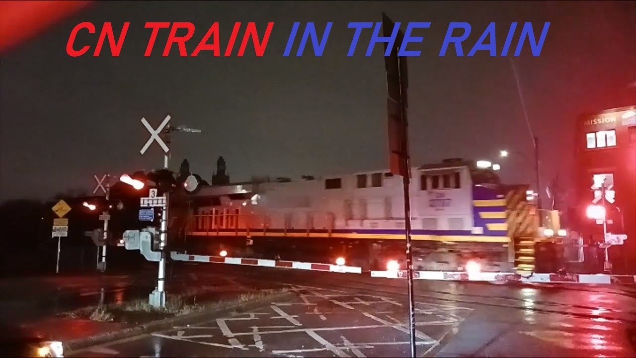 12 6 22 CN TRAIN IN THE RAIN AT MONTREAL LEVEL CROSSING - YouTube