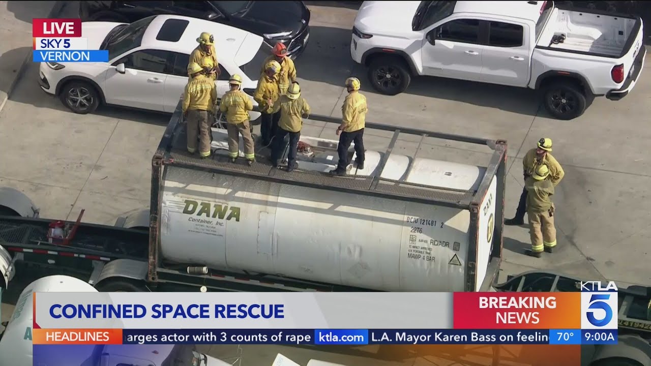 Fire crews rescue two that fell into container truck - YouTube