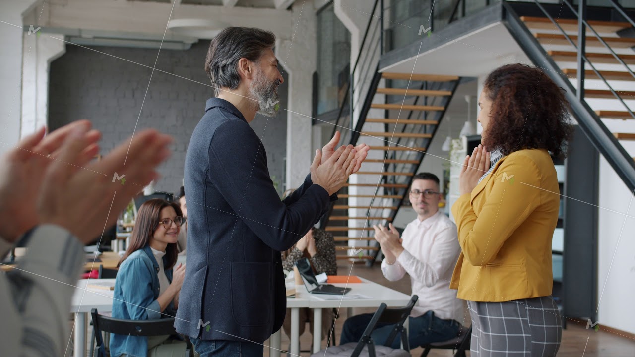 Boss shaking employee's hand giving good news while colleagues clapping ...