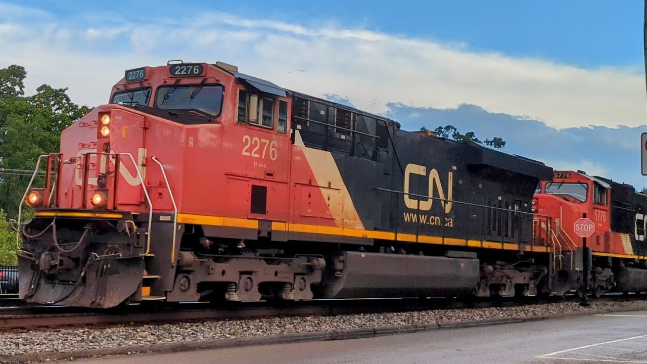 Two Canadian National locomotives leading Northbound empty ethanol tanks on track one - YouTube