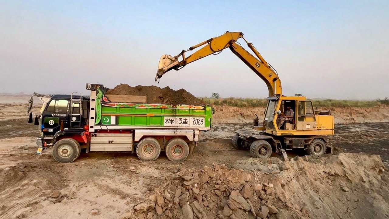 John Deere 595 Excavator Loading Nissan UD Dump Truck And Operator View ...