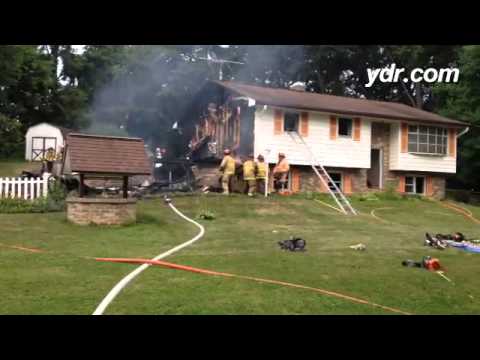 Firefighters use a chainsaw and pike poles to overhaul a house fire in ...