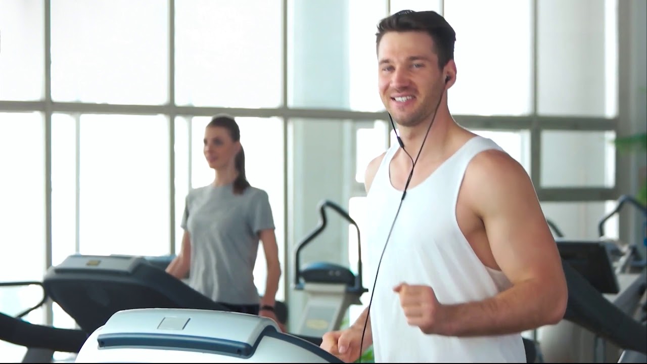 smiling athletic man running on treadmill slow motion handsome guy ...