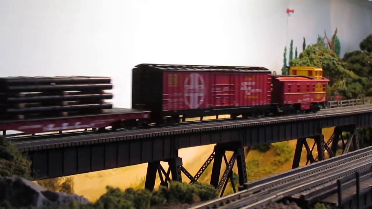 A 1960's era Santa Fe local freight crosses the tall steel bridge ...