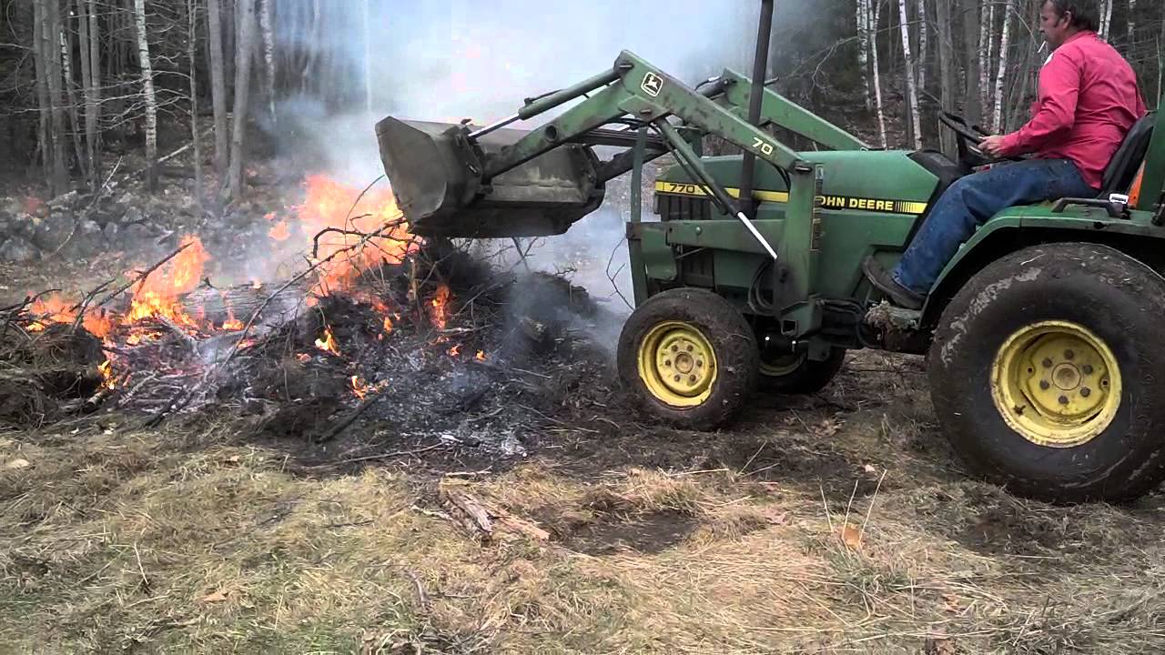 Tractor pushes burn pile - YouTube